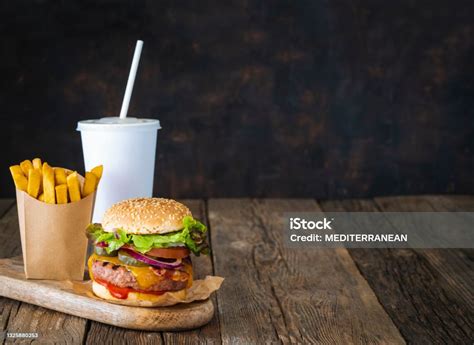 어두운 나무 테이블에 크래프트 종이 상자에 음료 빨대 유리와 일회용 감자 튀김을 가져 햄버거 콤보 메뉴판에 대한 스톡 사진 및