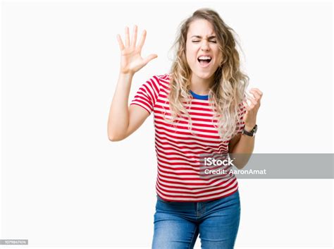 미친 미친 무기와 성공을 위한 축 하 하는 고립 된 배경 위에 아름 다운 젊은 금발의 여 자가 제기 하 고 흥분 비명 눈을 폐쇄 우승자 개념 T 셔츠에 대한 스톡 사진 및