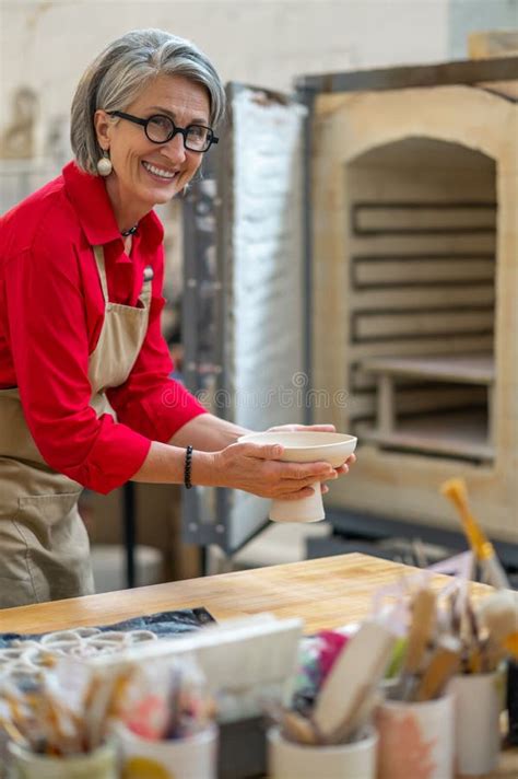 Craftswoman Holding Clay Plate Before Placing Into Kiln For Firing