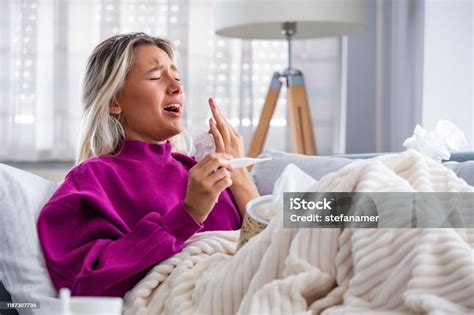 아픈 여자독감여자는 감기에 걸렸습니다 조직으로 재채기 두통 바이러스 의약품 젊은 여자 감염 에 감기 불고 그녀의 코 에 손수건 소파에 앉아 두통을 가진 아픈 여자 감기와