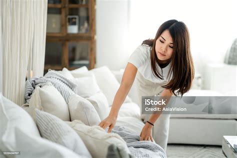 젊은 아시아 여자 조직 하 고 쿠션을 정리 하 고 집에서 거실에서 소파에 던져 가정의 방에 대한 스톡 사진 및 기타 이미지 가정의 방 정리 가정 생활 Istock
