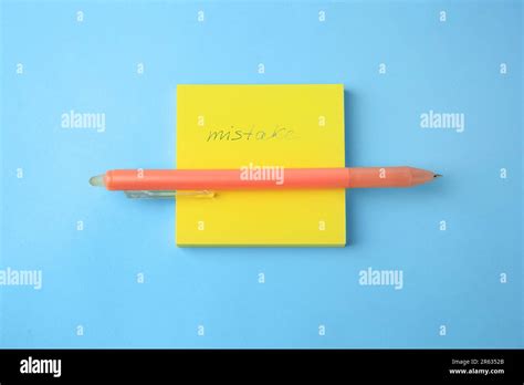 Paper Notes With Word Mistake And Erasable Pen On Light Blue Background