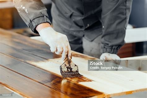 남자는 페인트 브러시로 나무 판을 칠합니다 목수 캐비닛 제작자는 나무 표면을 니스 칠합니다 진정한 워크플로 나무에 대한 스톡 사진 및 기타 이미지 Istock
