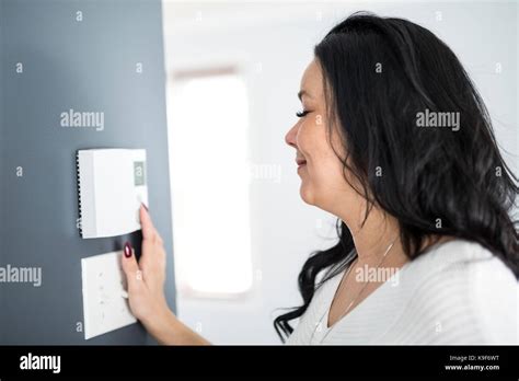 A Woman Programming The Temperature Inside Home Stock Photo Alamy