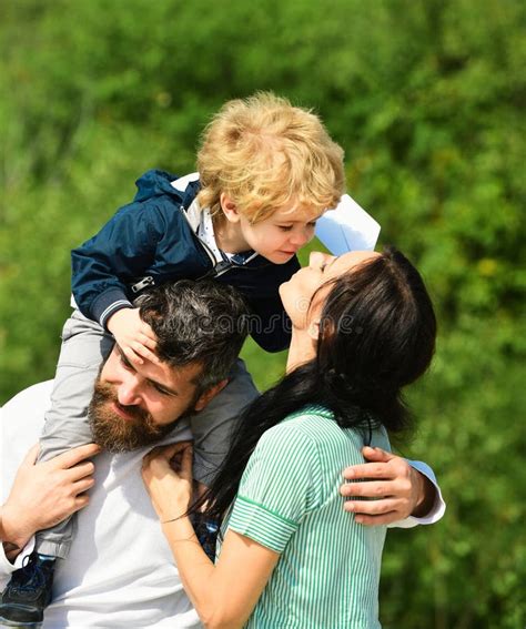 Retrato De Un Padre Feliz Dando A Su Hijo Un Paseo En Los Hombros Abrazando A Su Esposa Y