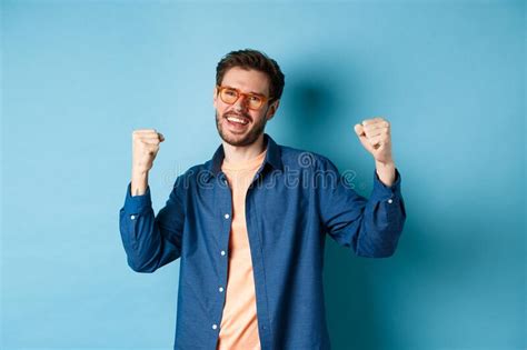Cheerful Young Man Celebrating Raising Hands Up And Saying Yes