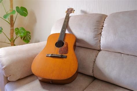 Velho Violão Deitado No Sofá Da Sala De Estar Foto Premium