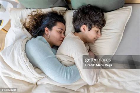 Lesbian Couple Cuddling While Sleeping In Bed Together High Res Stock