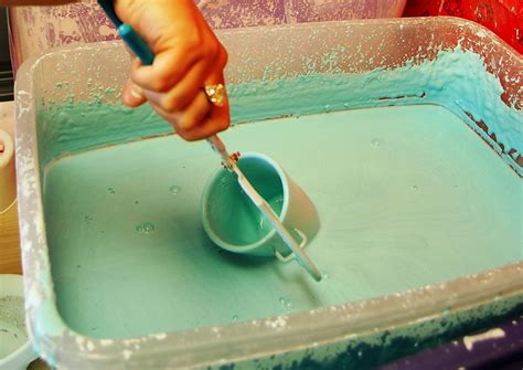 A Person Is Holding A Toothbrush In A Cup