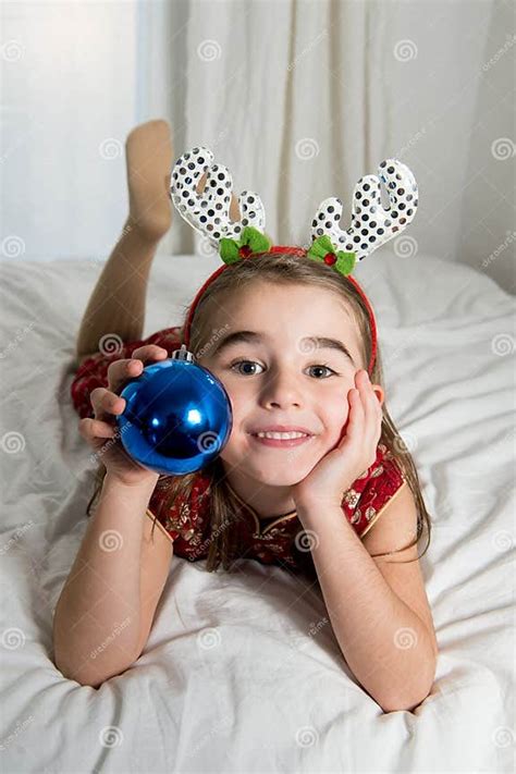 Милая маленькая девочка лежа на кровати с пузырем рождества Стоковое