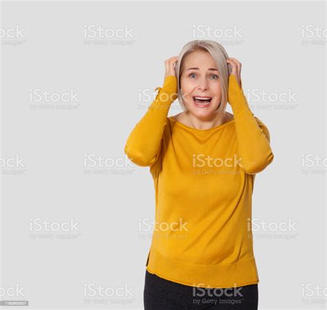 중년 금발 감정적으로 스튜디오에서 포즈 흰색 배경에 노란색 밝은 스웨터에 행복한 여자 귀여운에 대한 스톡 사진 및 기타 이미지