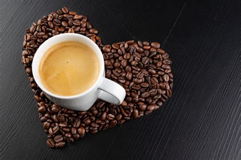 볶은 커피 콩 테이블에 심장의 모양에 배열 흰색 머그잔에 맛 있는 향기로운 커피 어두운 배경입니다 0명에 대한 스톡 사진 및 기타 이미지 Istock