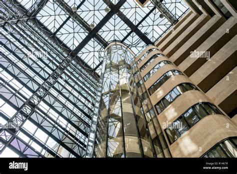 Interior Facade Of Modern Building With Glass Elevator And Balconies
