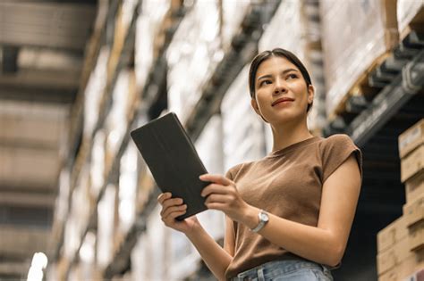 젊은 여성 관리자 근로자 체크리스트는 창고에서 소포 상자 제품을 관리합니다 매장 업계에서 일하는 태블릿을 사용하는 아시아 여성 감독자 물류 수입 수출 개념 경영자에 대한