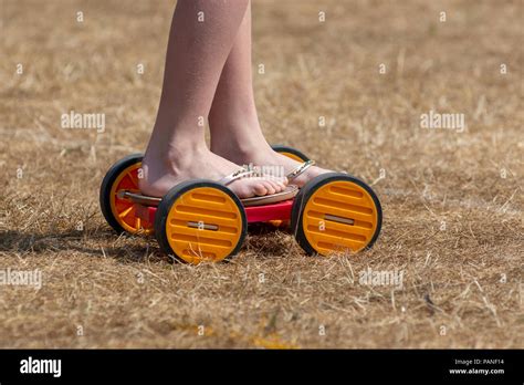 Girls Bare Feet Wearing Flip Flops Riding A Pedal Driven Set Of Wheels