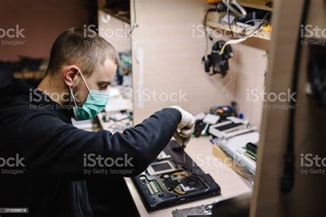 실험실에서 랩톱을 수리하는 기술자 수리 컴퓨터 전자 업그레이드 기술의 개념 코로나 바이러스 작업장에서 보호 마스크를 착용 작업