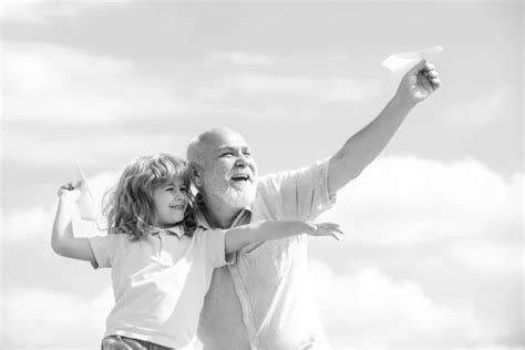 Viejo Abuelo Y Nieto Niño Pequeño Con Avión De Papel De Juguete Contra
