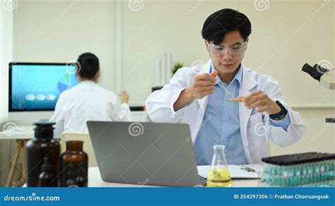 Microbiologist Or Researcher In White Coat With Petri Dish Examining