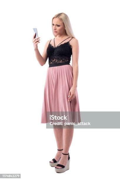 의심스러운 불쾌한 젊은 금발의 여자는 화가 표정으로 휴대 전화에 뉴스를 읽고 20 29세에 대한 스톡 사진 및 기타 이미지 20 29세 Full Body
