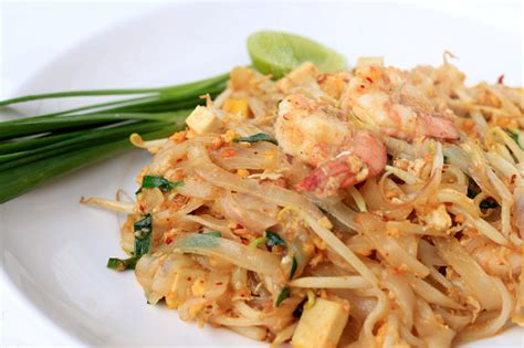 태국 스타일 국수 패드 태국어 볶음된 쌀국수 새우 흰색 배경에 흰색 접시에 야채와 함께 제공합니다 태국의 국가 메인 요리 중 하나입니다 태국에서 인기 있는 음식 고급 요리에