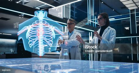 두 명의 생명공학자가 미래 실험실에서 심장과 혈류가 있는 인간 가슴의 컴퓨터 기반 Vfx 홀로그램을 작업하고 있다 2명에 대한 스톡 사진 및 기타 이미지 Istock