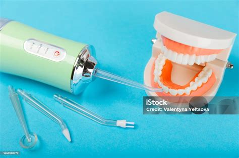 배경에 전자 구강 세정기 구강 위생을위한 치과 도구 전기 치간 청소기 치과용 물 샤워 구강 관리 개념입니다 텍스트를 위한 위치입니다 복사 공간 이빨에 대한 스톡 사진 및