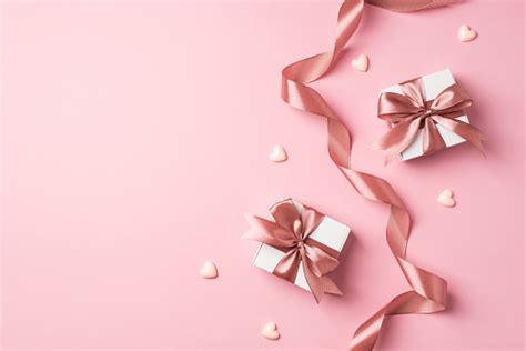발렌타인 데이 장식 곱슬 실크 리본 두 개의 작은 선물 상자의 상단 보기 사진 활과 카피 스페이스와 고립 된 파스텔 핑크 배경에 작은 마음 리본에 대한 스톡 사진 및 기타