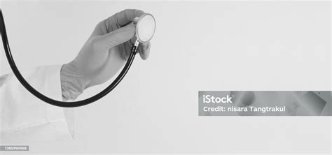 의사는 청진기로 손을 잡고 손을 잡았습니다 핸드는 파란색 의료 용 장갑과 흰색 배경에 긴 소매 가운을 착용합니다 흑백 사진 건강 진단에 대한 스톡 사진 및 기타 이미지