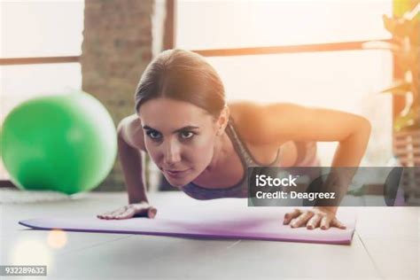 낮은 각도의 아름 다운 자신감 지 구동 성공 Sportswoman 화창한 날 태양 광선 광속 섬광에 보라색 바닥 카펫에 팔 굽 혀 펴기를 하 고 초상화 닫기 사람 얼굴에