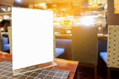 라벨 바 레스토랑에서 빈 메뉴 프레임을 모의 스탠드 나무 테이블 식당 흐리게 배경에 흰색 시트 종이 아크릴 텐트 카드와 소책자에 대 한 고객의 텍스트 삽입 수 있습니다 깨끗