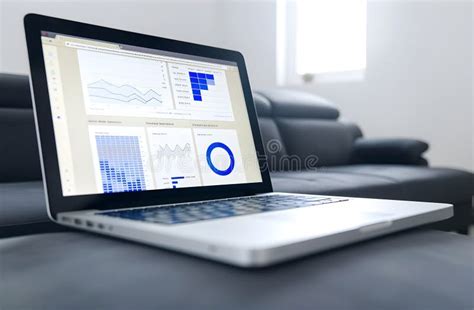 Laptop Displaying Data On Dashboard In Front Of Couch Stock