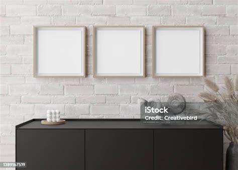 현대 거실의 흰색 벽돌 벽에 세 개의 빈 사각형 사진 프레임 미니멀하고 현대적인 스타일로 인테리어를 모의하세요 사진 포스터를 위한 여유 공간 콘솔 조각 3d 렌더링 액자에