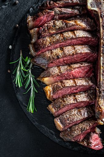 바비큐 숙성 와규 포터하우스 스테이크는 슬레이트 보드에서 최고의 전경으로 썬 소고기 Tbone 육즙이 많은 스테이크 희귀