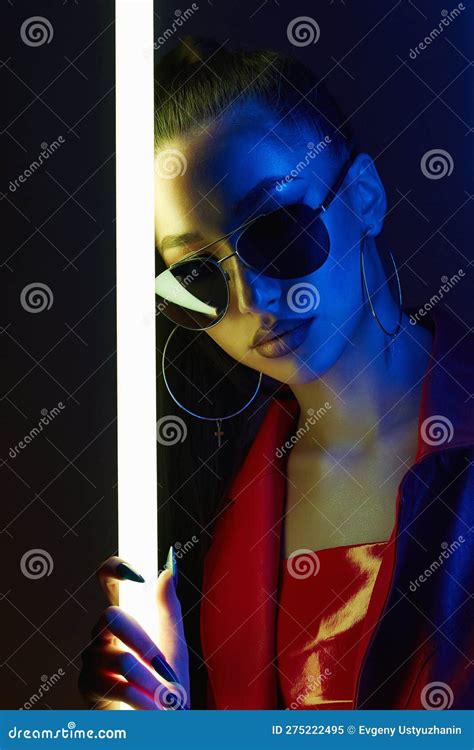 красивая молодая женщина с неоновой лампой красивая девушка в солнечных очках Стоковое
