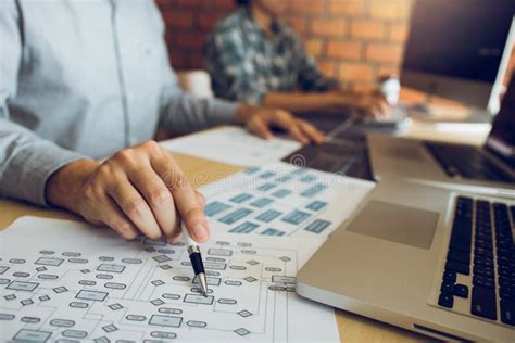 Software Developer Is Pointing To The Paper Working And Analyzing