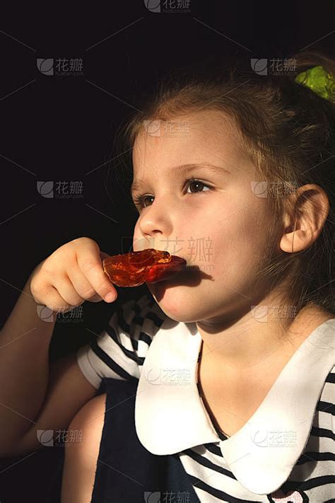 手里拿着棒棒糖的小女孩，夕阳的光和影。素材 花瓣网