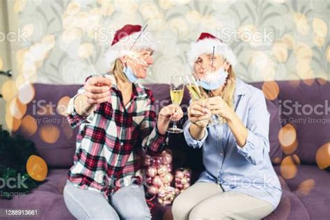 메리 크리스마스와 해피 홀리데이 샴페인 잔과 함께 건배하고 카메라를 보고 크리스마스 모자를 쓴 행복한 웃는 소녀 두 명 35 39세에 대한 스톡 사진 및 기타 이미지