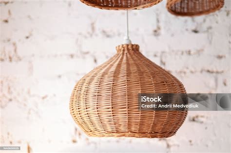 세 개의 등나무 샹들리에는 흰색 벽돌 벽 배경에 다른 형태입니다 아늑한 거실에 있는 짚 전등갓 천연 소재를 사용한 친환경 인테리어 디자인 스칸디나비아 인테리어 복사 공간