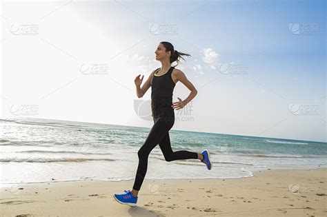 运动女孩在外面训练。她正在海边跑步。