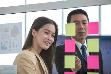 직장에서 이야기하는 아시아 비즈니스 팀 남성과 여성 동료들은 선상에서 차트와 아이디어를 공유하고 행복한 젊은 프리젠 테이션 동료들은 기내에서 함께 일합니다 경영자에 대한