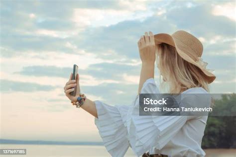 스마트 폰에서 셀카를 찍는 소녀의 초상화 젊은 아름다운 30 년 여성 백인 모양에 빨대 모자와 사틴 리본 활 공간을 복사합니다 여름 라이프 스타일 컨셉 자연스러운 배경