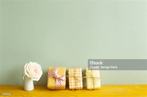 노란색 선물 상자와 나무 테이블에 흰색 장미 꽃의 꽃병 카키 그린 배경 0명에 대한 스톡 사진 및 기타 이미지 0명 3가지