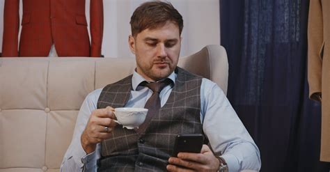 A Classy Man Drinking Coffee While Using His Phone Free Stock Video