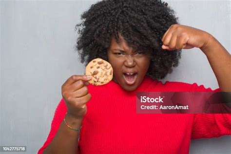 회색 그런 지 동안 젊은 아프리카계 미국인 여자 벽 화가 초콜릿 칩 쿠키 먹고 미친과 제기 손으로 소리 분노와 좌절 외치고 분노 개념 감정에 대한 스톡 사진 및 기타 이미지