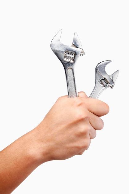 Premium Photo Cropped Hand Holding Spanner Over White Background