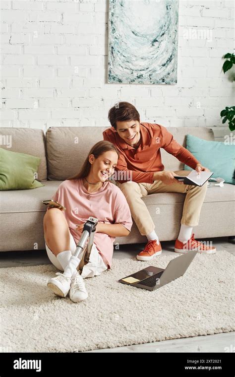 A Young Couple Relaxes On A Couch Together The Woman With A Prosthetic