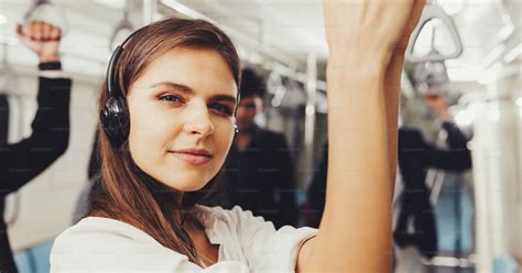 현대 지하철 열차에서 헤드폰과 셔츠를 입고 서 있는 아름다운 젊은 여성 승객 사진 Unsplash의 태국 이미지
