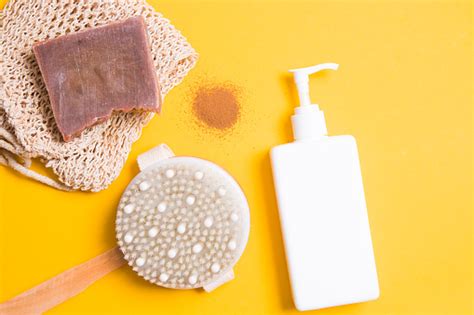 라벨이 없는 디스펜서가 있는 화이트 포콘 드라이 마사지를 위한 브러시 수제 초콜릿 비누 니트 수건으로 노란 배경에 간 커피 한 줌 각질제거에 대한 스톡 사진 및 기타 이미지