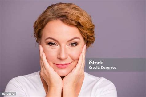 클로즈업 사진 아름 다운 놀라운 성숙한 그녀는 그녀의 여자 자신 있게 봐 확인 터치 얼굴 완벽 한 신선한 부드러운 뺨 광대 뼈 워시 로션 얼룩 크림 착용 흰색 T 셔츠 고립