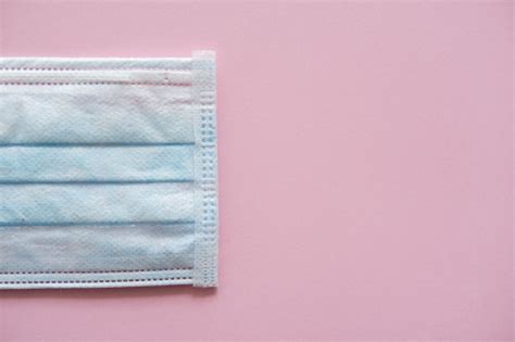 분홍색 배경에 고립 된 파란색 의료 보호 마스크 코로나바이러스를 방지하기 위해 입과 코를 덮는 일회용 3ply 의료 용 마스크